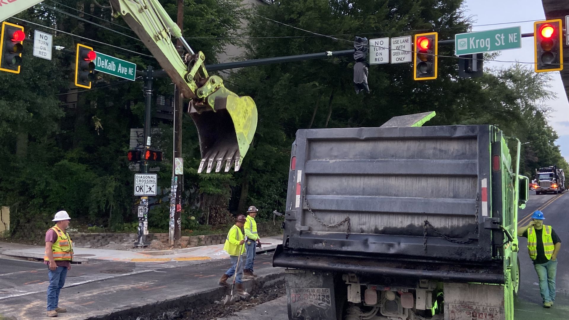 Construction crews use a digger to tear up the road on DeKalb Avenue