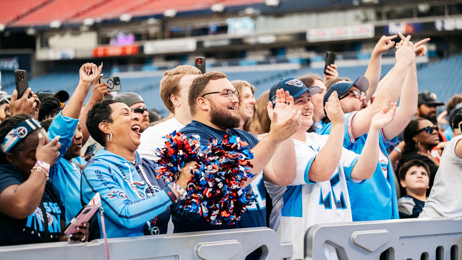 Tennessee Titans fans clap and celebrate during a game, showing ...