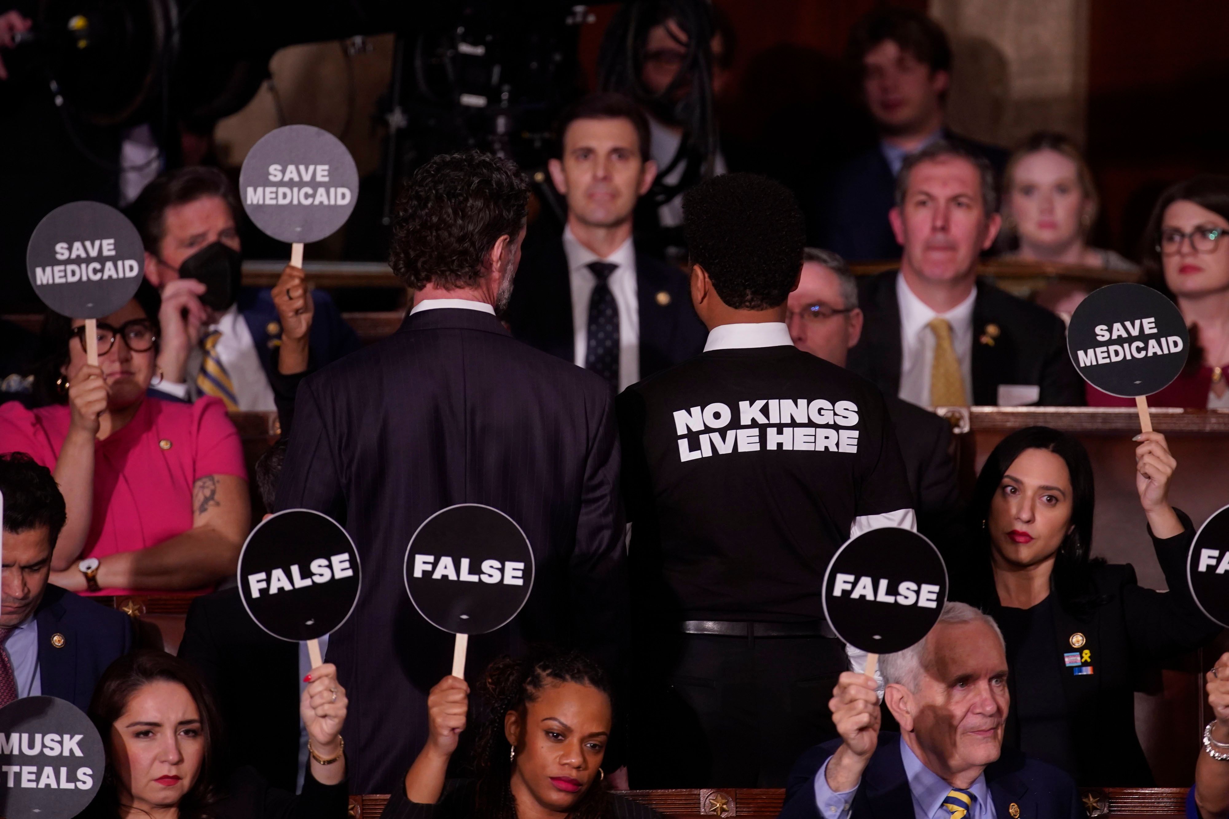 Photos: Trump's speech protested by Democrats holding up signs, wearing ...